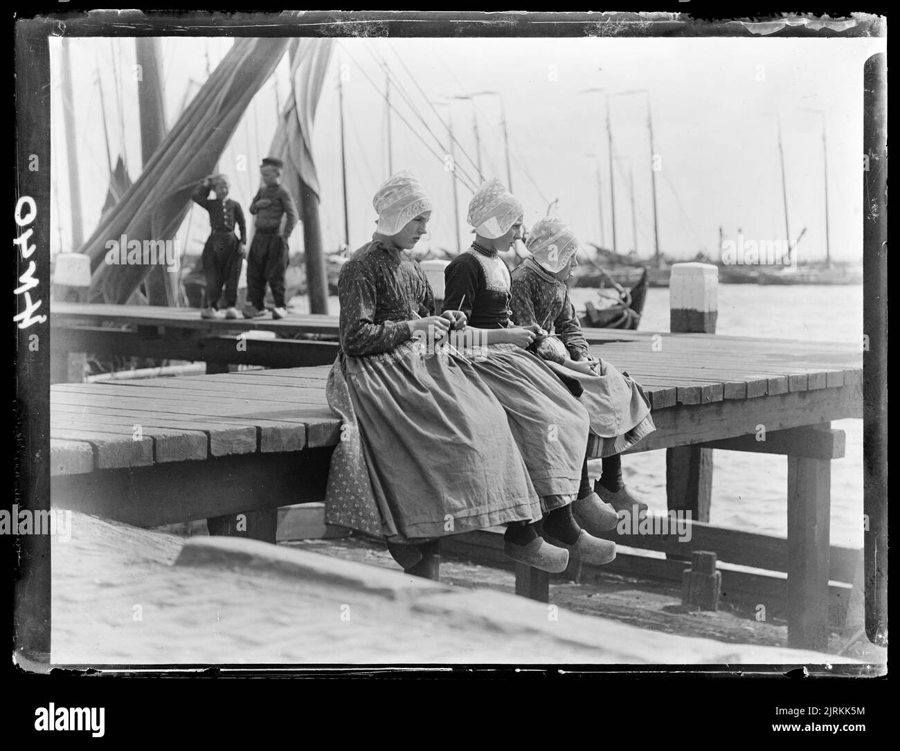 Three girls sitting on a dock, the Netherlands, 1906-1917, Netherlands, by George Crombie Stock ...
