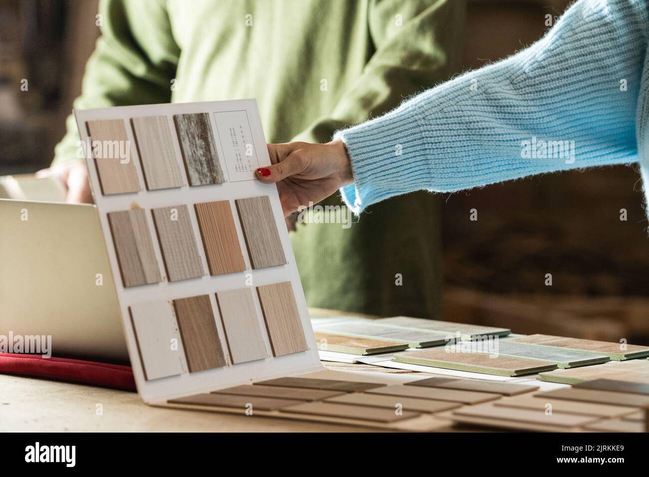 Cropped unrecognizable craftsman helping female client in picking ...