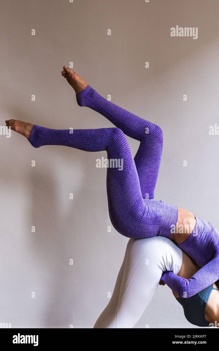 Side view of cropped unrecognizable fit woman lying on back of female ...