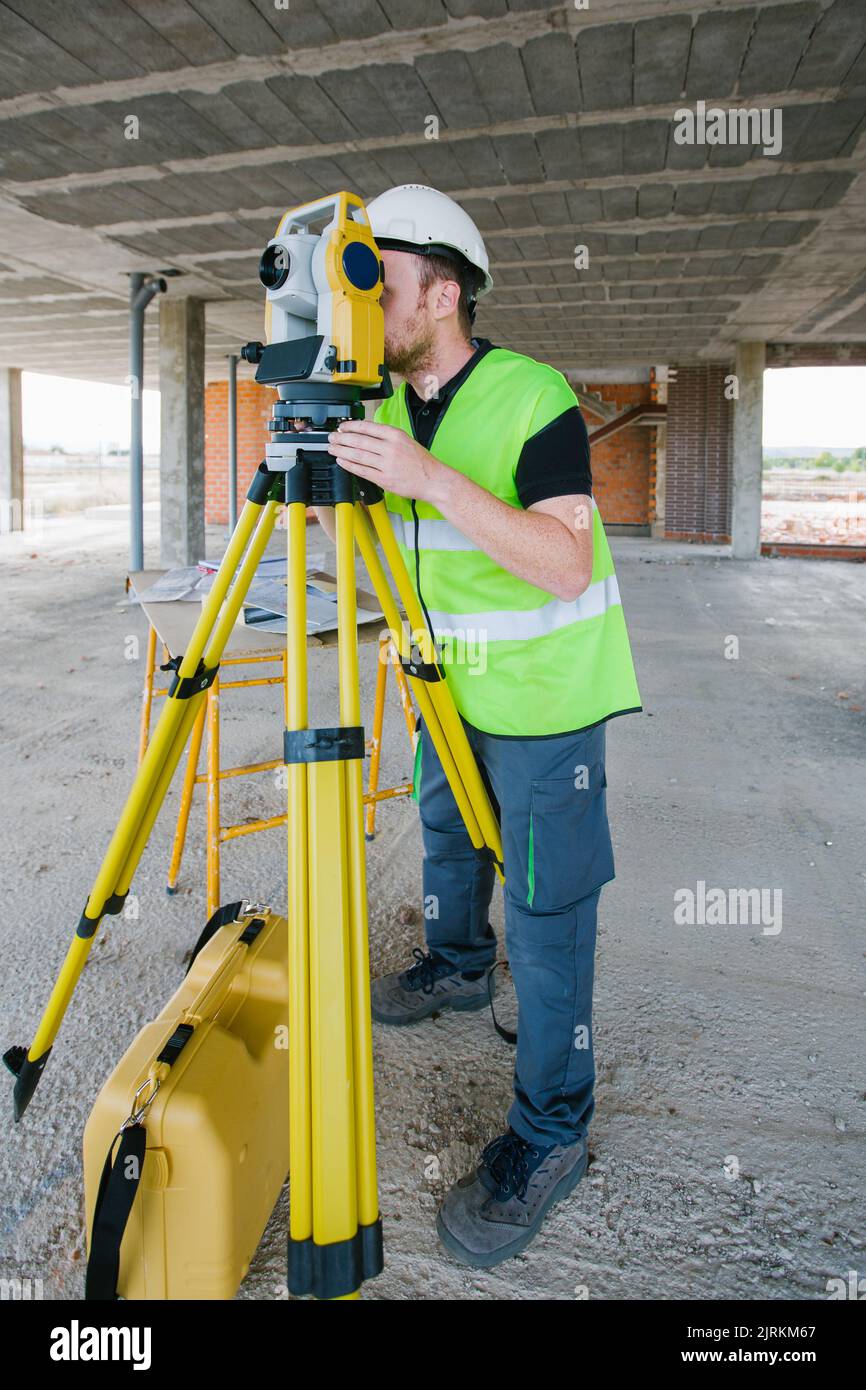 Surveyor engineer working at construction site with measuring equipment ...