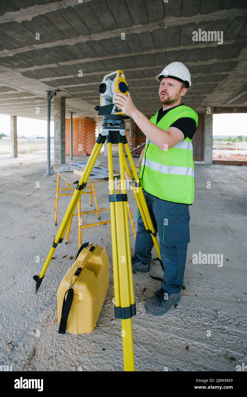 Surveyor engineer working at construction site with measuring equipment ...