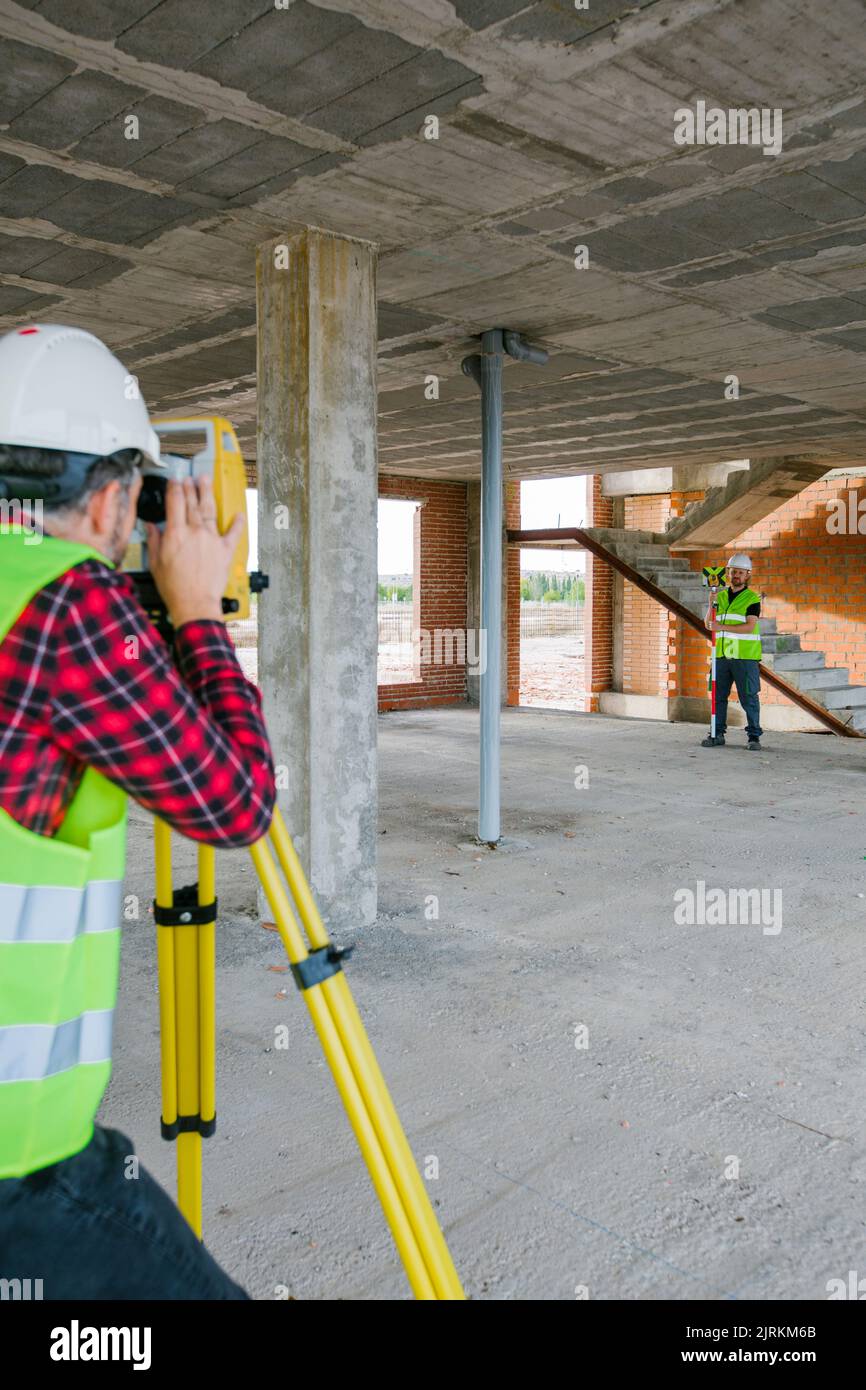 Surveyor engineer working at construction site with measuring equipment ...