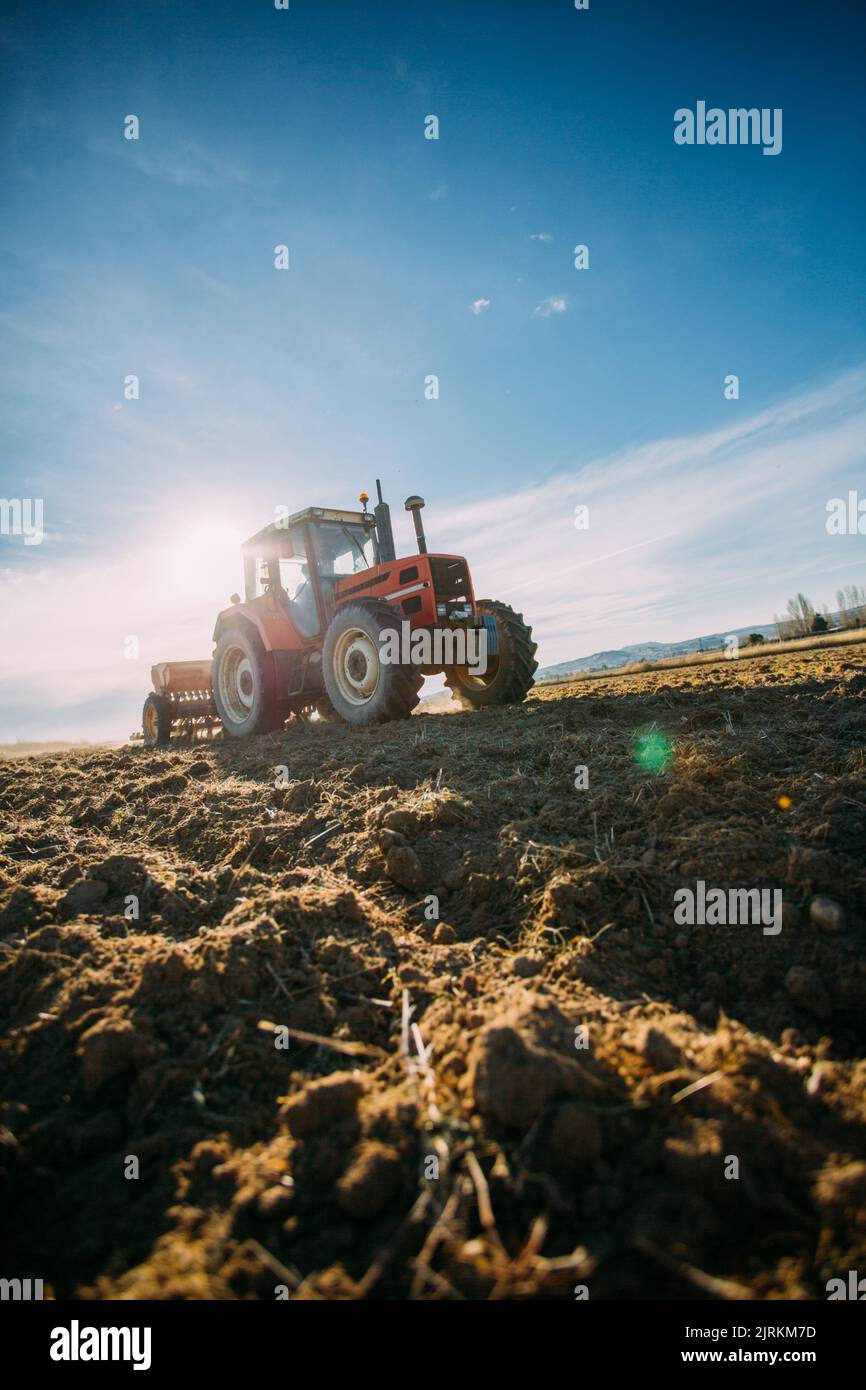 Old tractor working on the field Stock Photo - Alamy