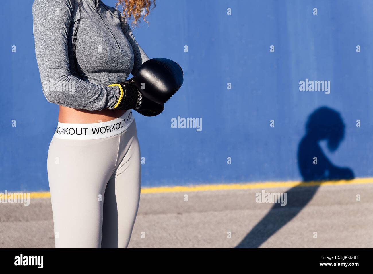 Side view of anonymous determined adult female boxer putting on boxing ...