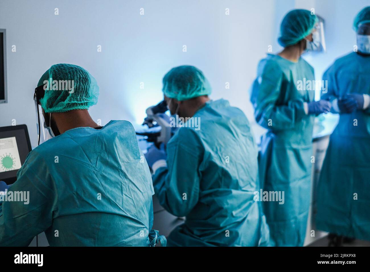 Medical workers in hazmat suit working with microscope inside modern ...