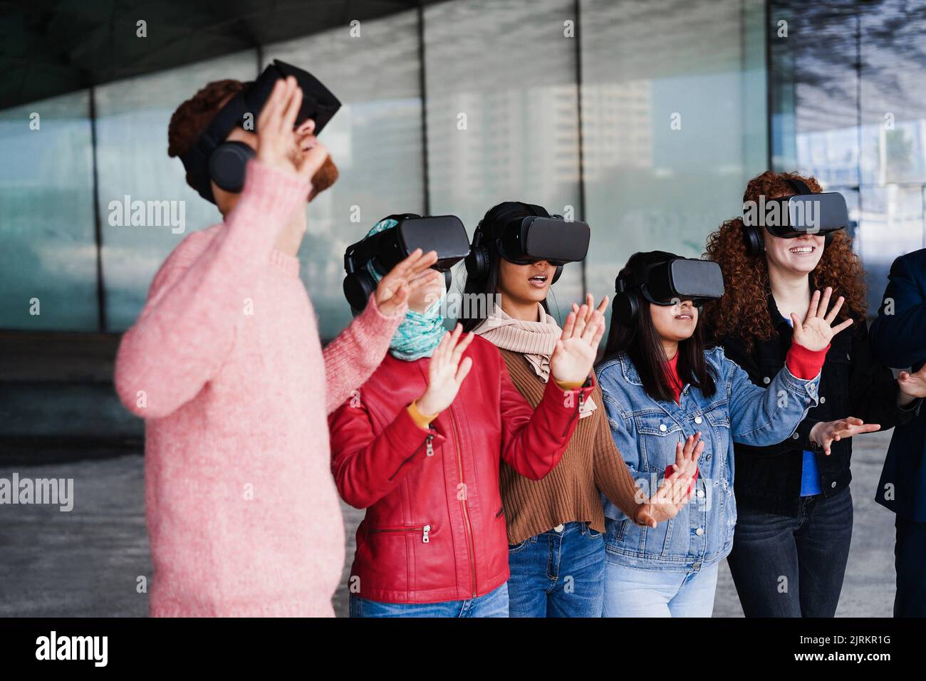 Young people wearing virtual headsets outdoor - Focus girl face wearing ...