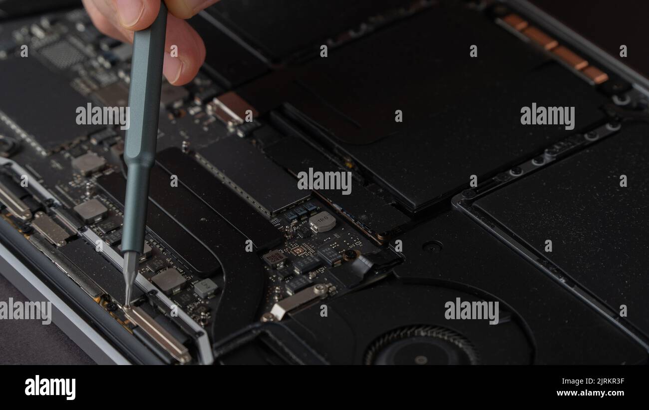Screwdriver unscrews the screw on the laptop, the internal components ...