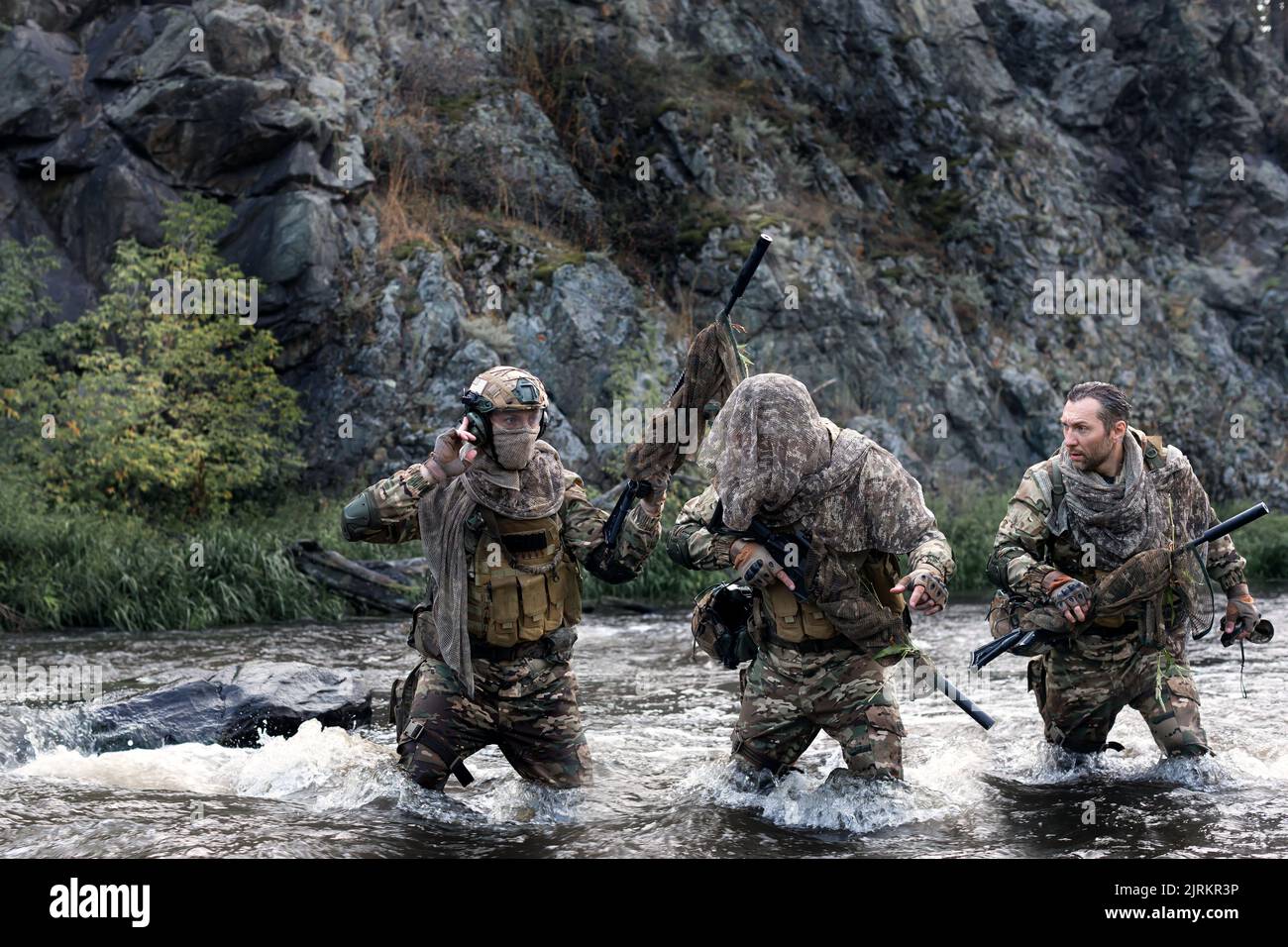 Three soldiers ford a river during a special operation. Concept of ...
