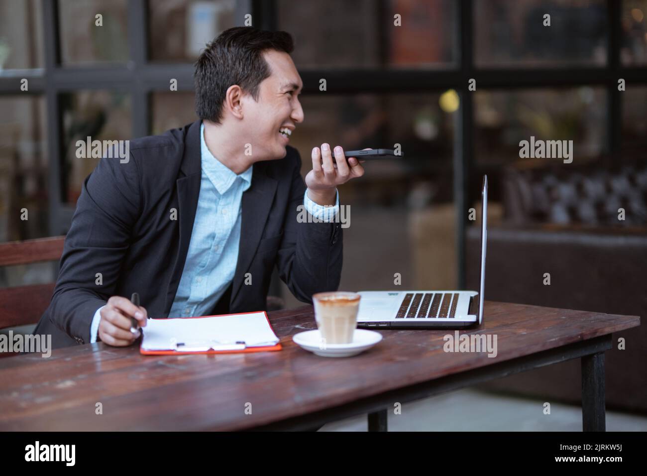 businessman having a phone call while working alone at cafe Stock Photo ...