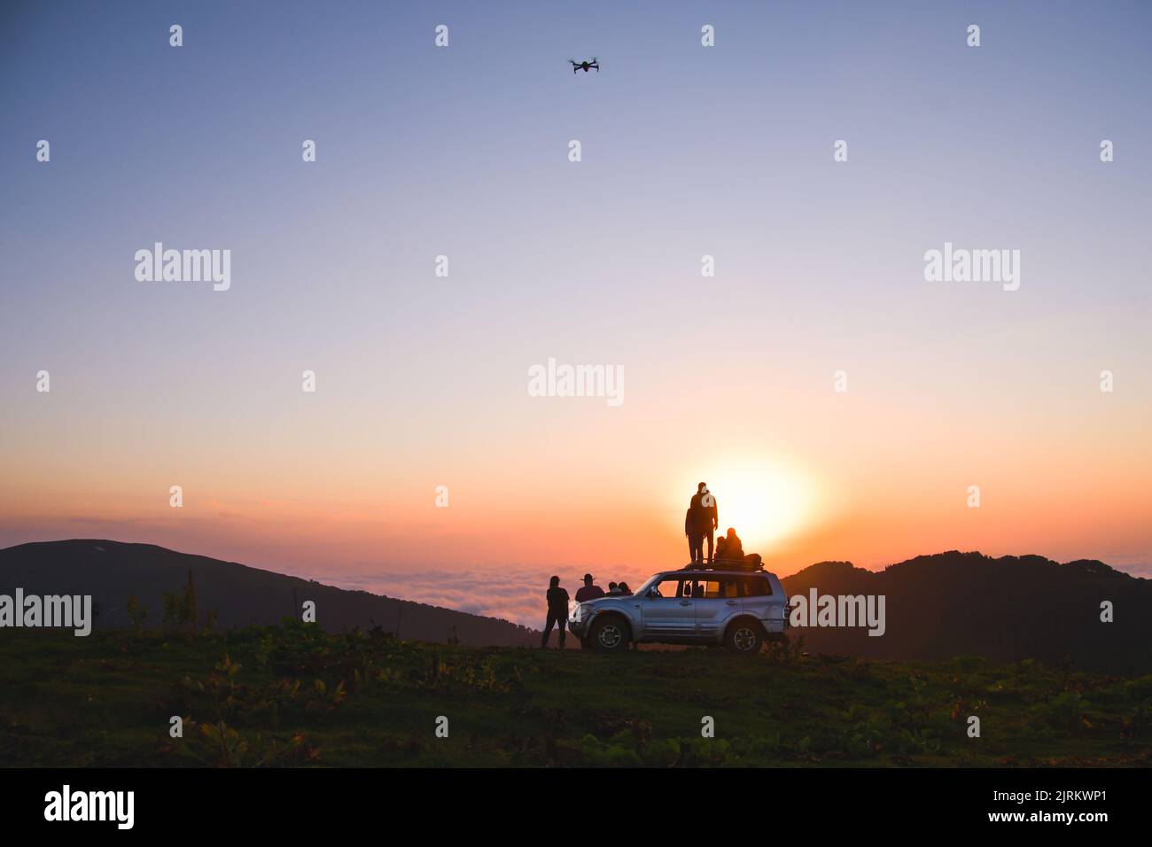Group of travelers content creators stand by 4wd vehicle together ...