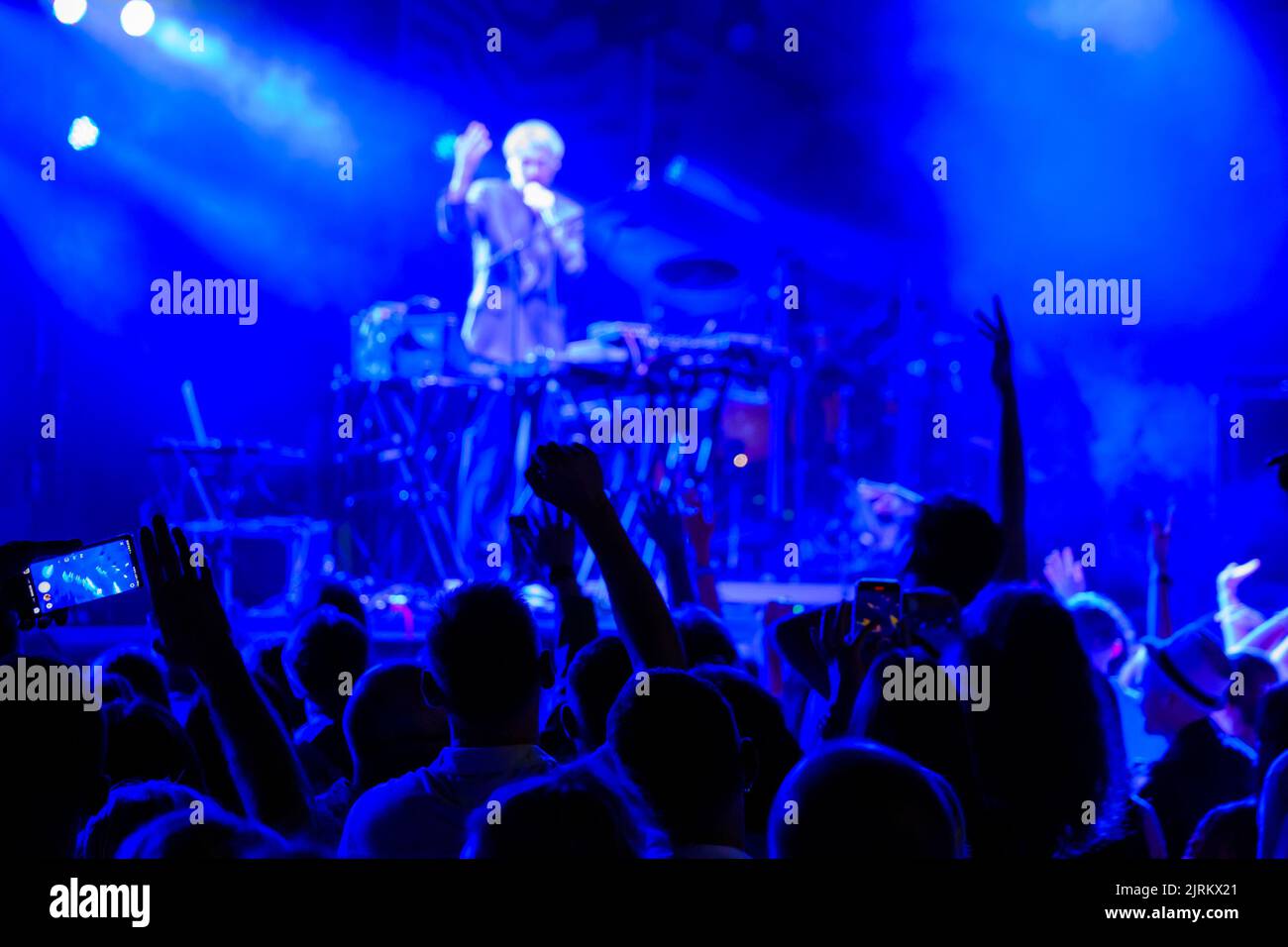 Silhouette of unrecognizable male vocalist pointing up and talking to ...