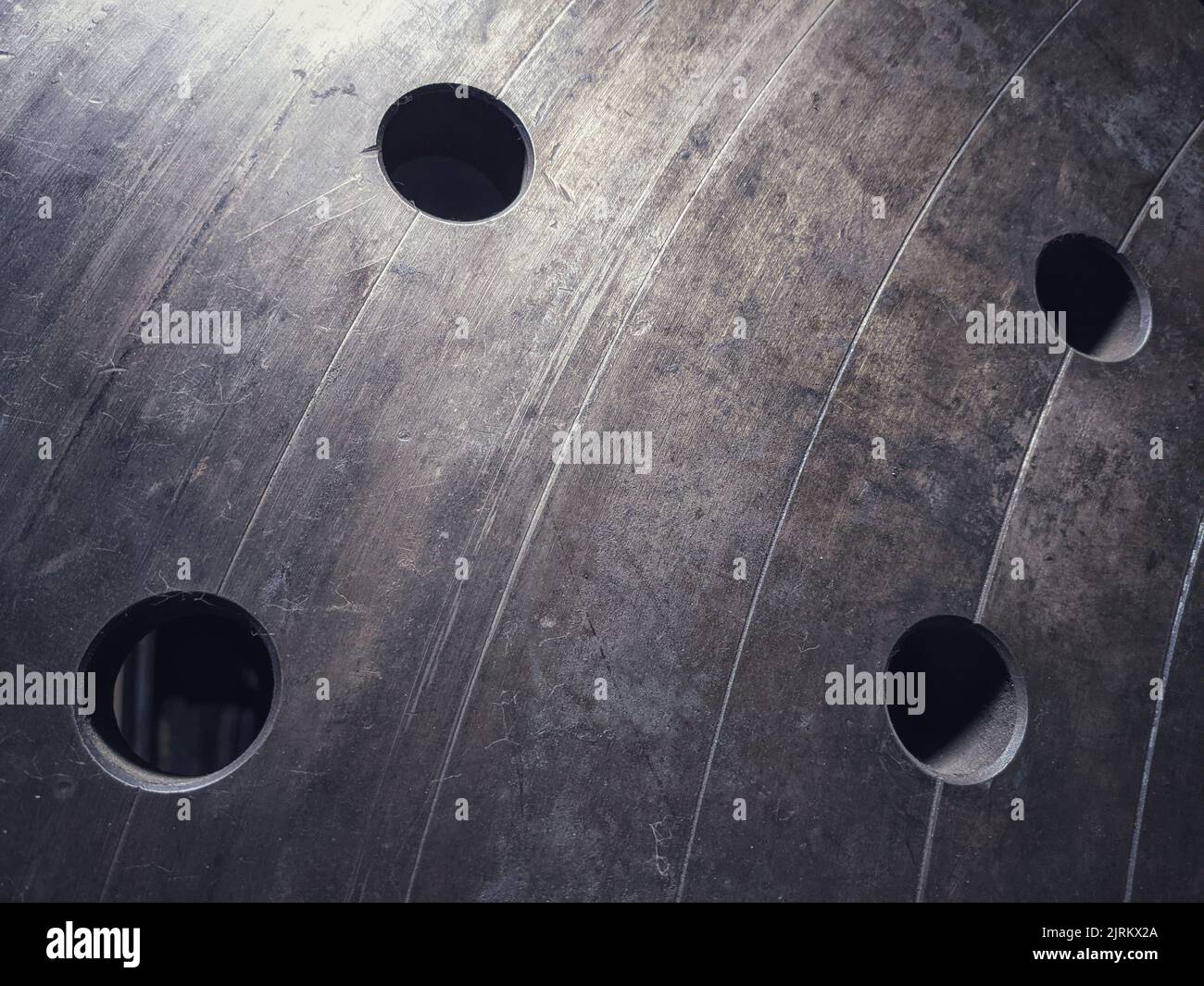 A closeup shot of a four holes on a steel plate Stock Photo - Alamy