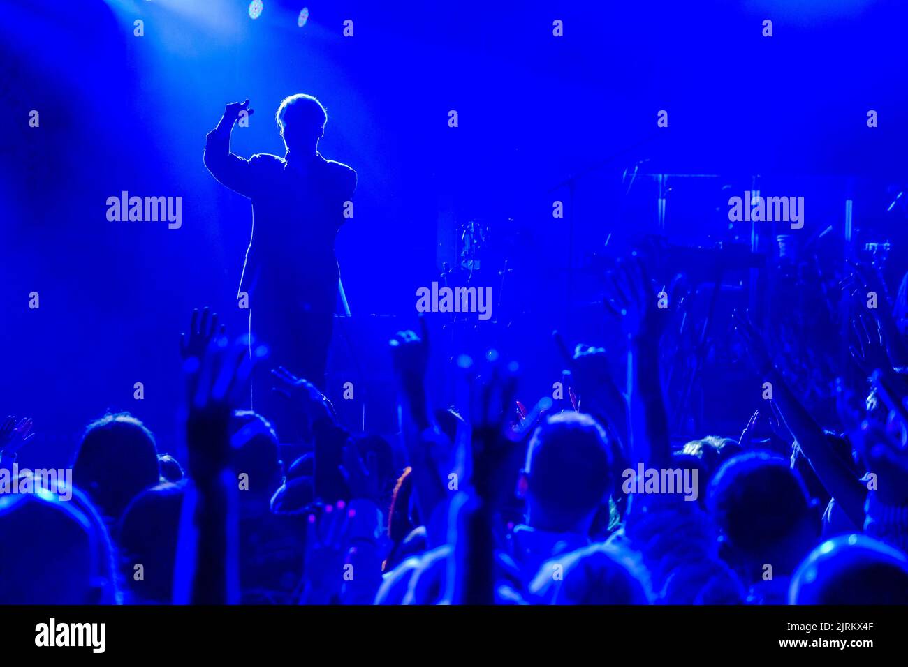 Silhouette of unrecognizable male vocalist pointing up and talking to ...
