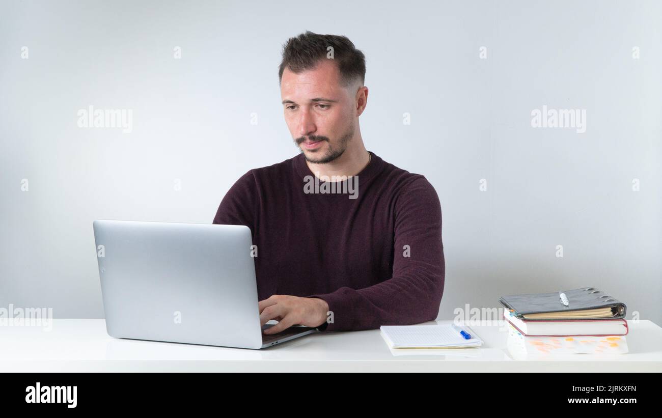 Concentrated work, a man works at a laptop at an office desk Stock ...