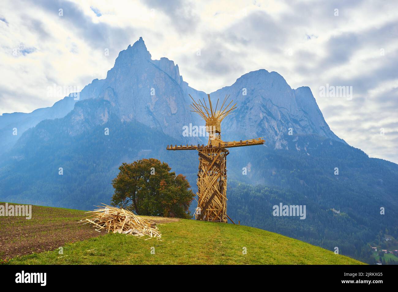 Statue of a wooden Burning man above the Catinaccio Group, seen by ...