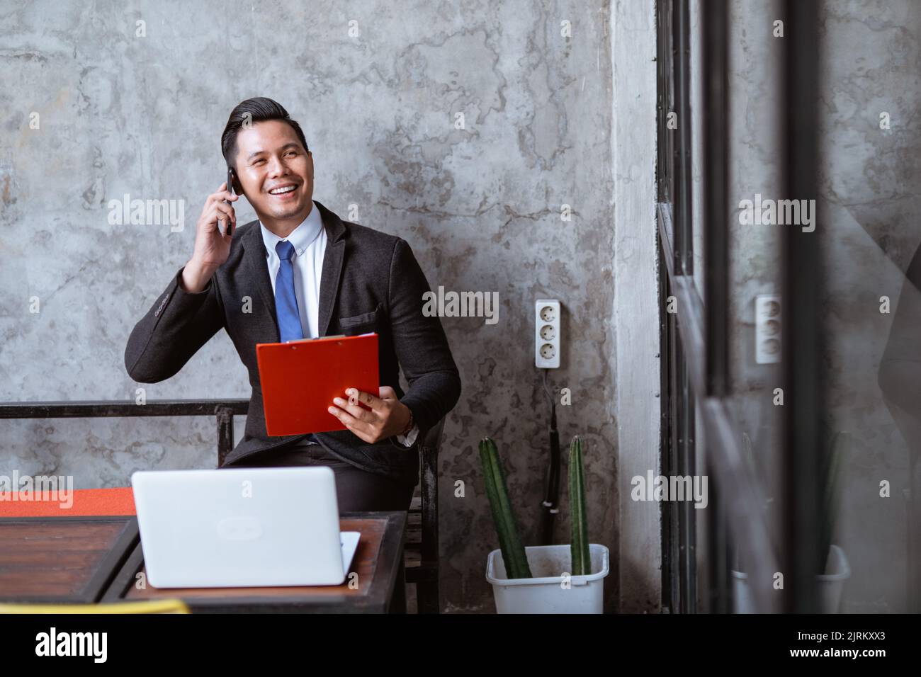 businessman having a discussion through his phone while working Stock ...