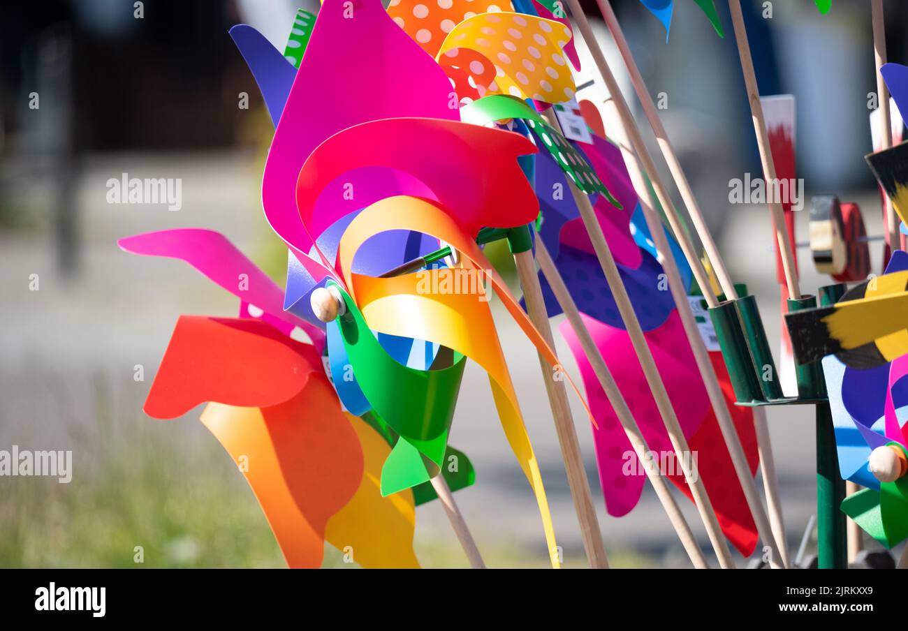 Colorful wind-powered toys. Children's toys on a market stall. Summer ...