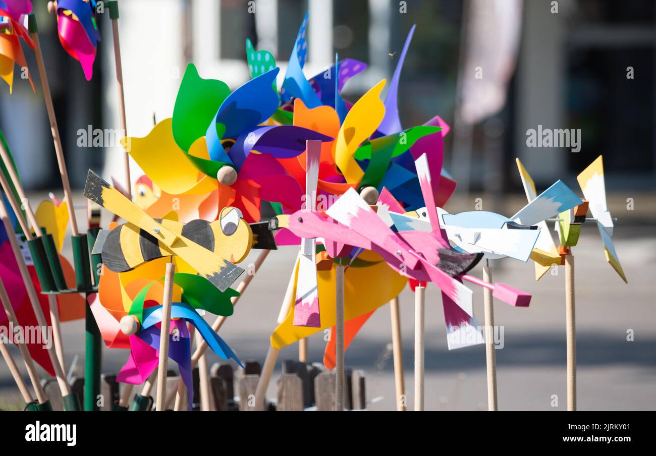 Colorful wind-powered toys. Children's toys on a market stall. Summer ...