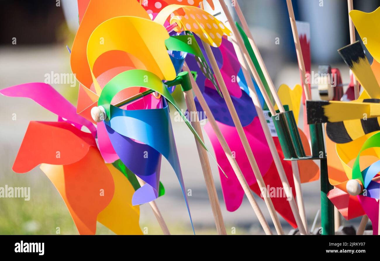 Colorful wind-powered toys. Children's toys on a market stall. Summer ...