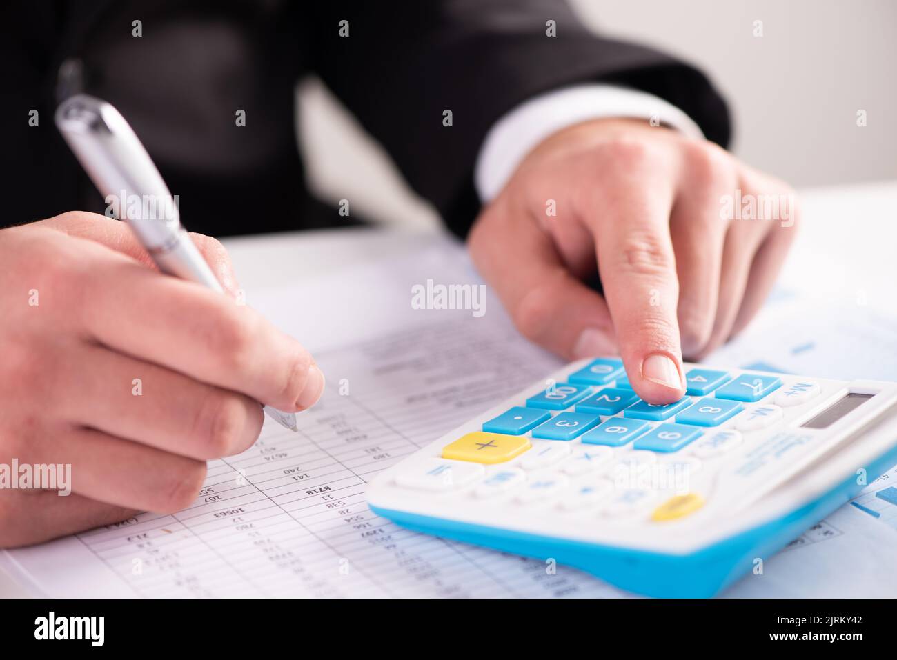 A finger adding up figures using a calculator close up Stock Photo - Alamy