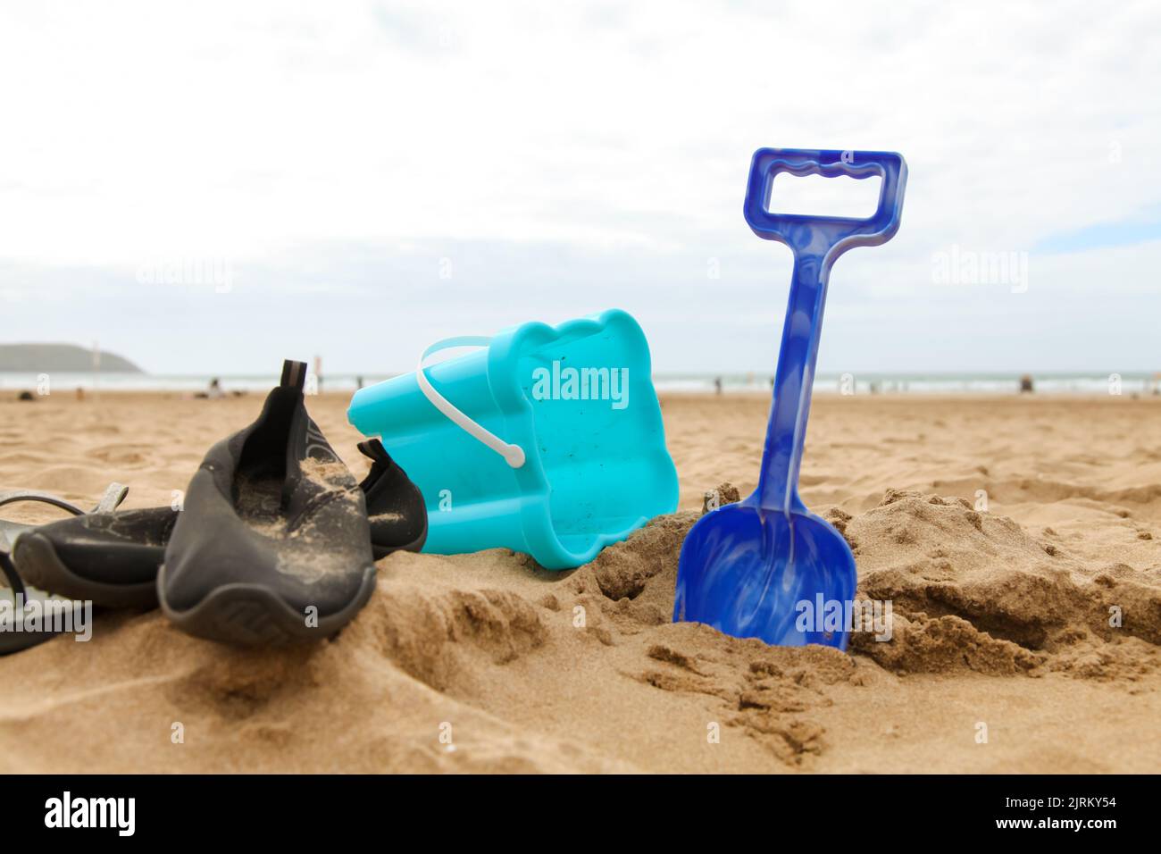 Bucket and Spade with beach shoes in sand at Woolacombe beach, North ...