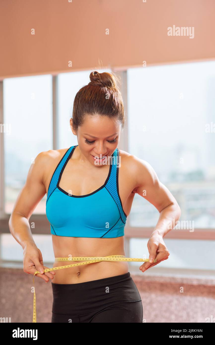Muscular female measuring her waist hi-res stock photography and images ...