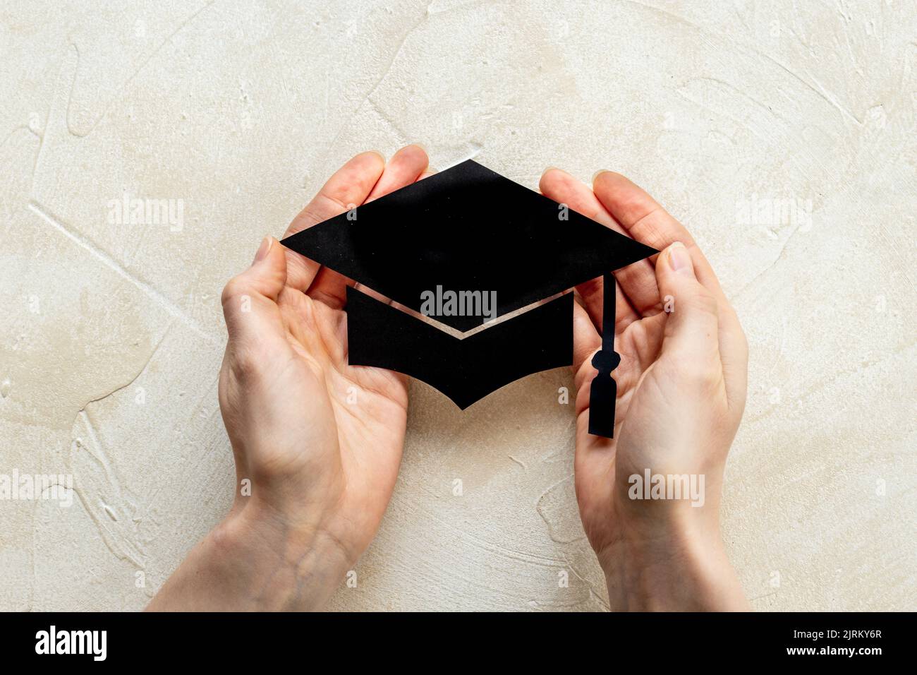 Hands holding graduation hat or academic cap paper cut. Education ...