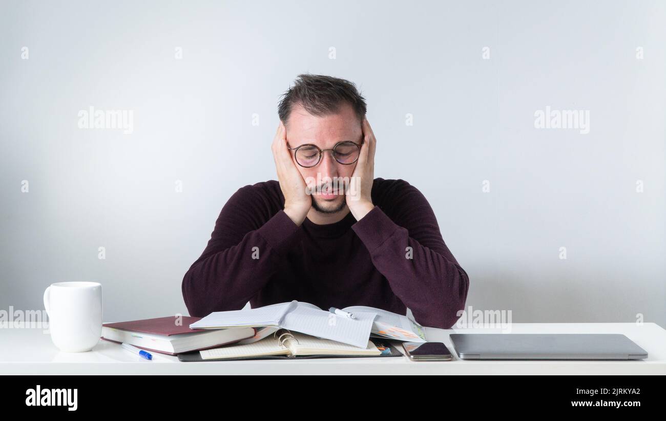 Routine and a lot of tasks at work - a male employee solves complex ...