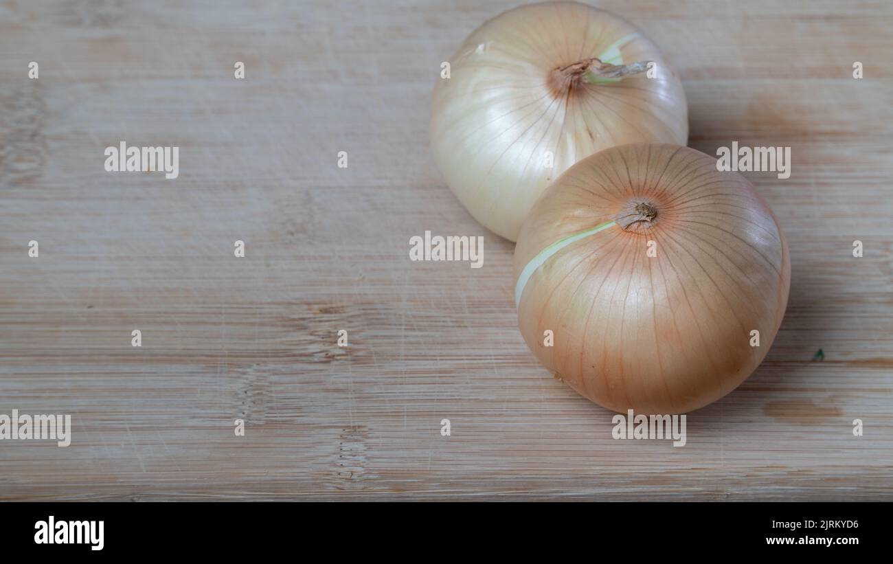 Onions in husks on a wooden board vegetables background Stock Photo - Alamy