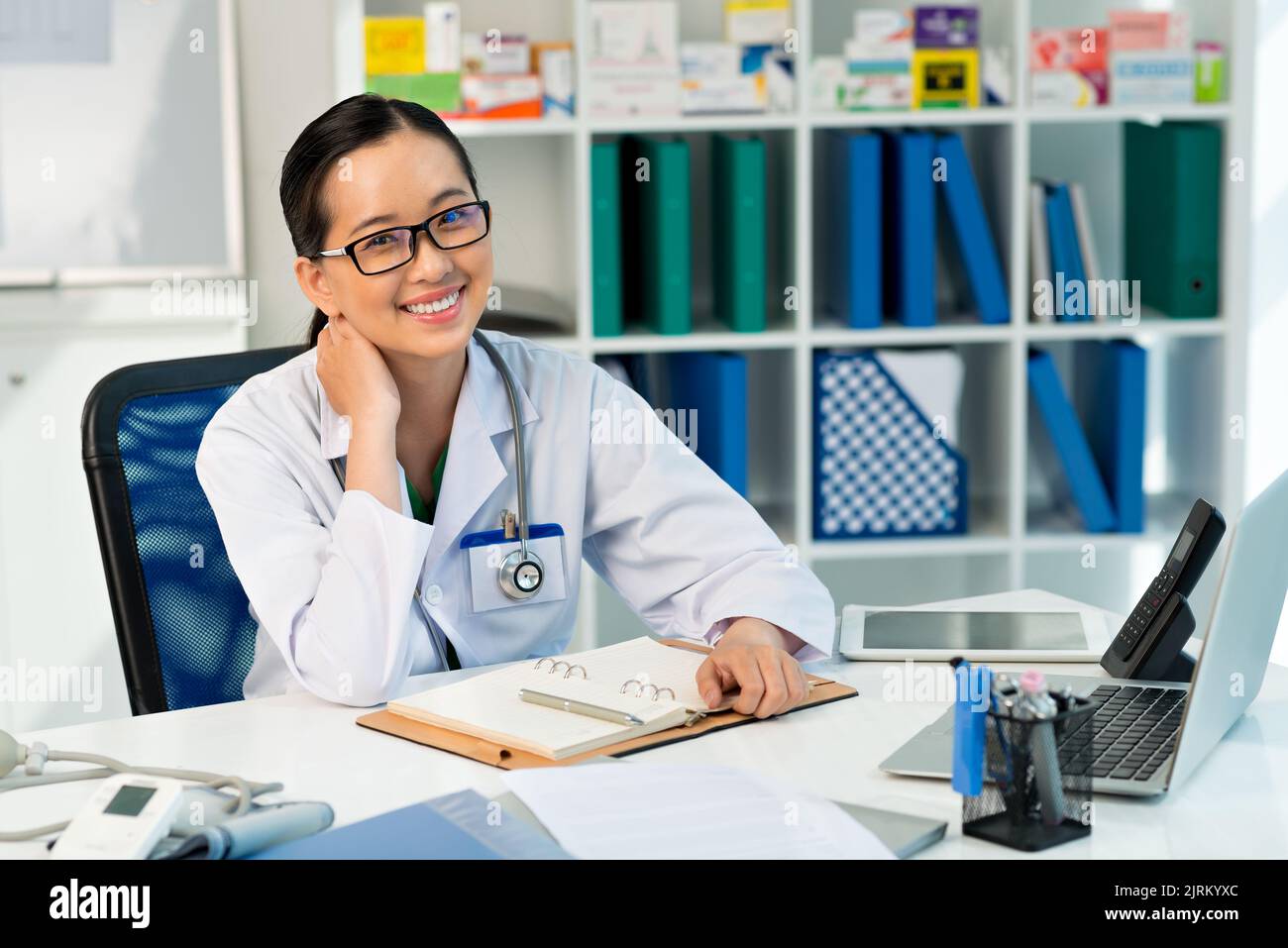 Pretty smiling Vietnamese doctor at her table Stock Photo - Alamy