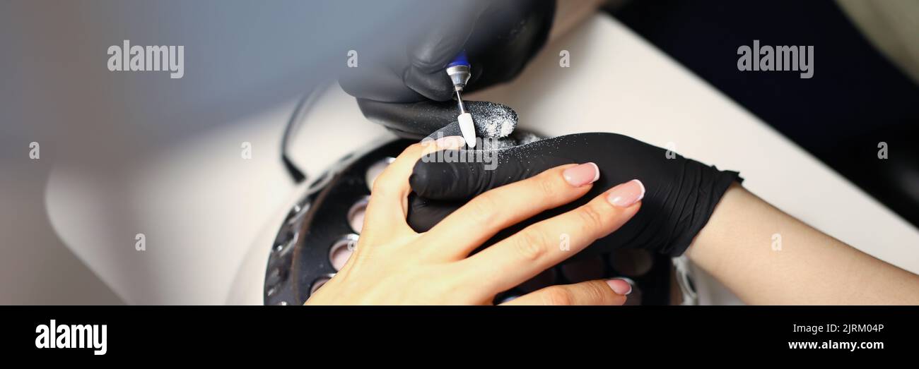 Woman master making manicure to client using special machine in beauty ...