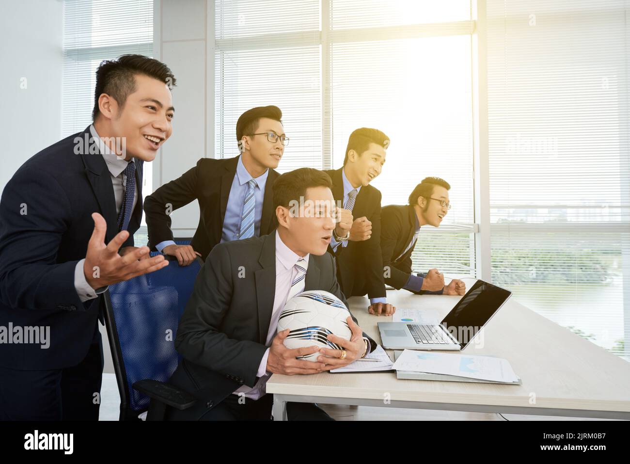 Group of cheerful Asian businessmen wearing classical suits gathered ...