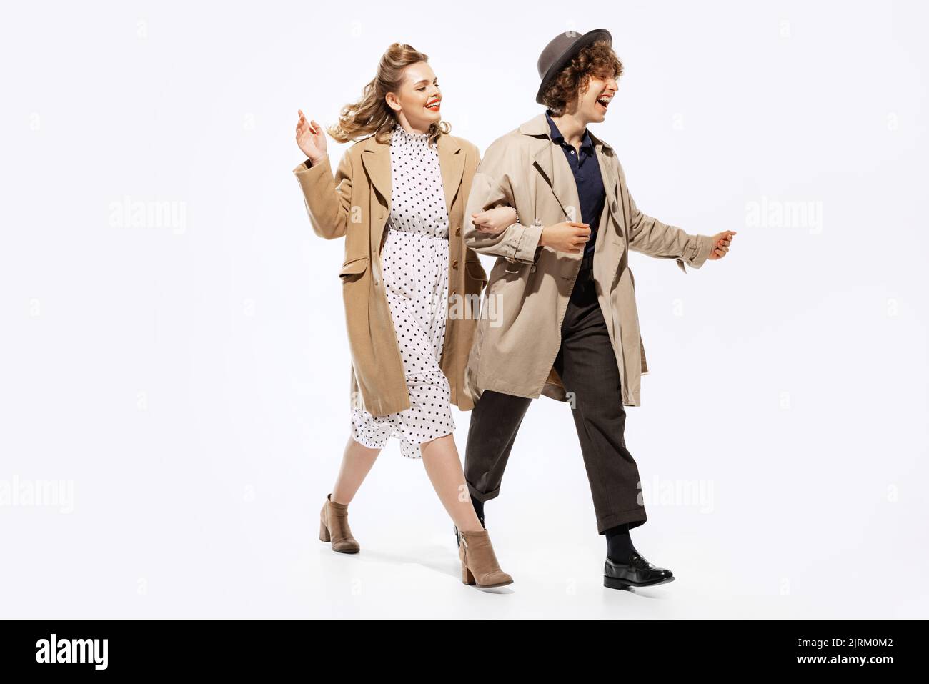 Excited young couple, stylish man and pretty woman in 70s, 80s fashion ...