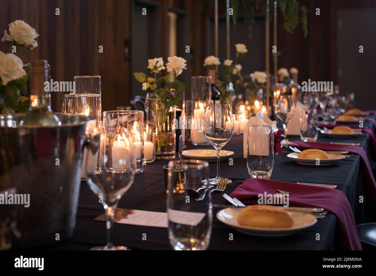 A decorated view of the table setting with candles, white roses ...