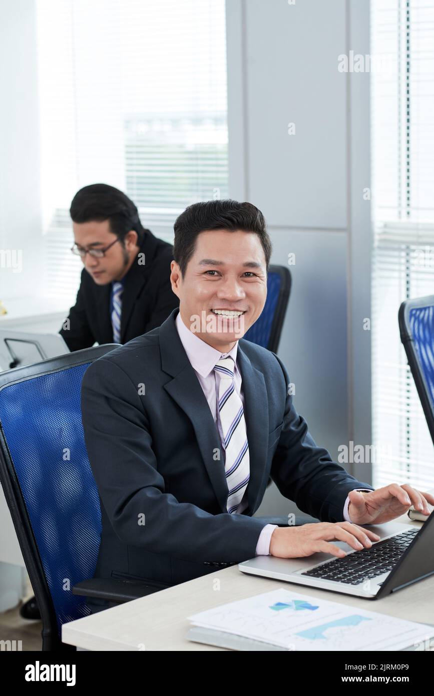 Waist-up portrait of middle-aged Asian manager wearing suit posing for ...