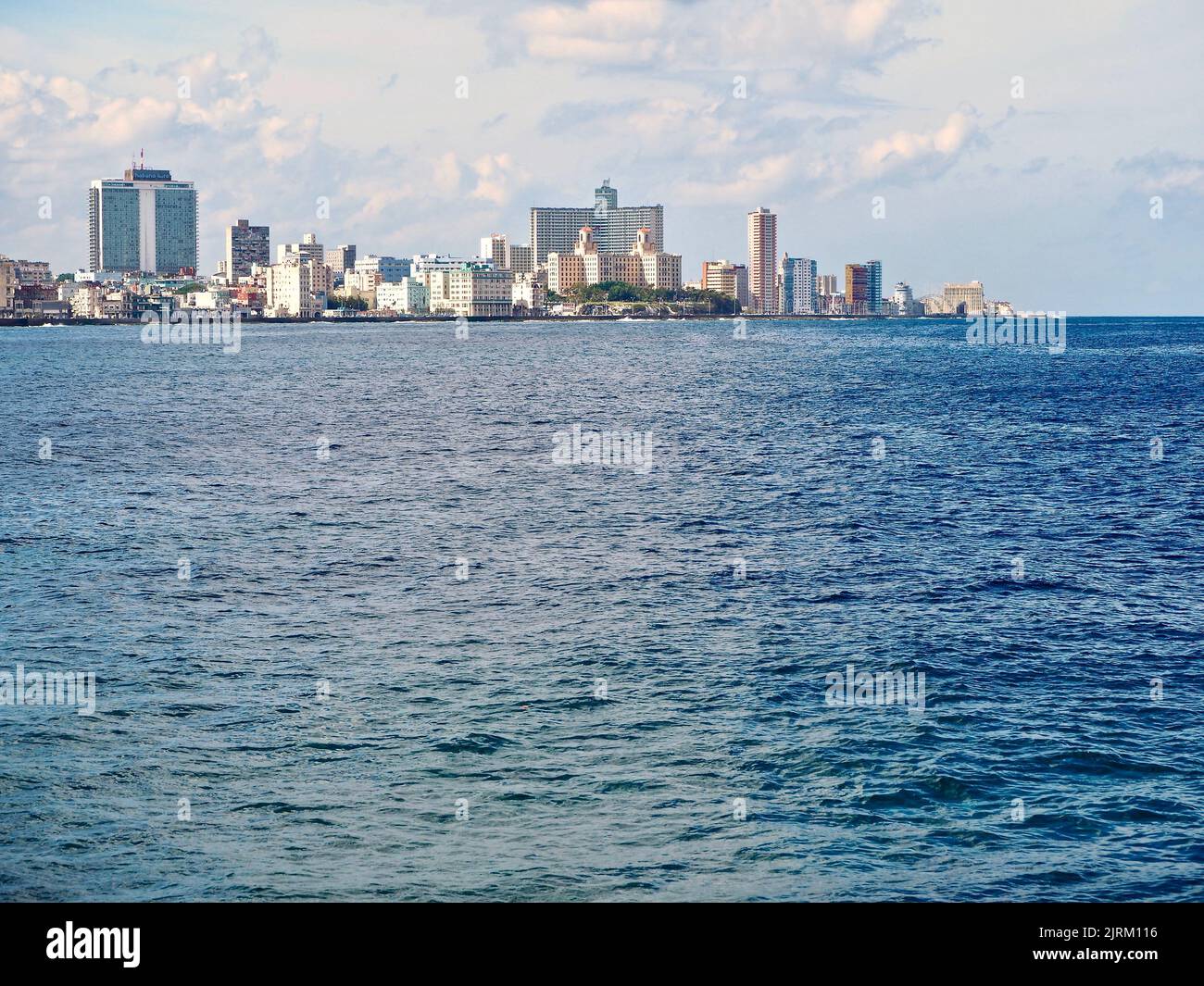 A view of Havana's skyline across blue water on a hot sunny day, Cuba ...