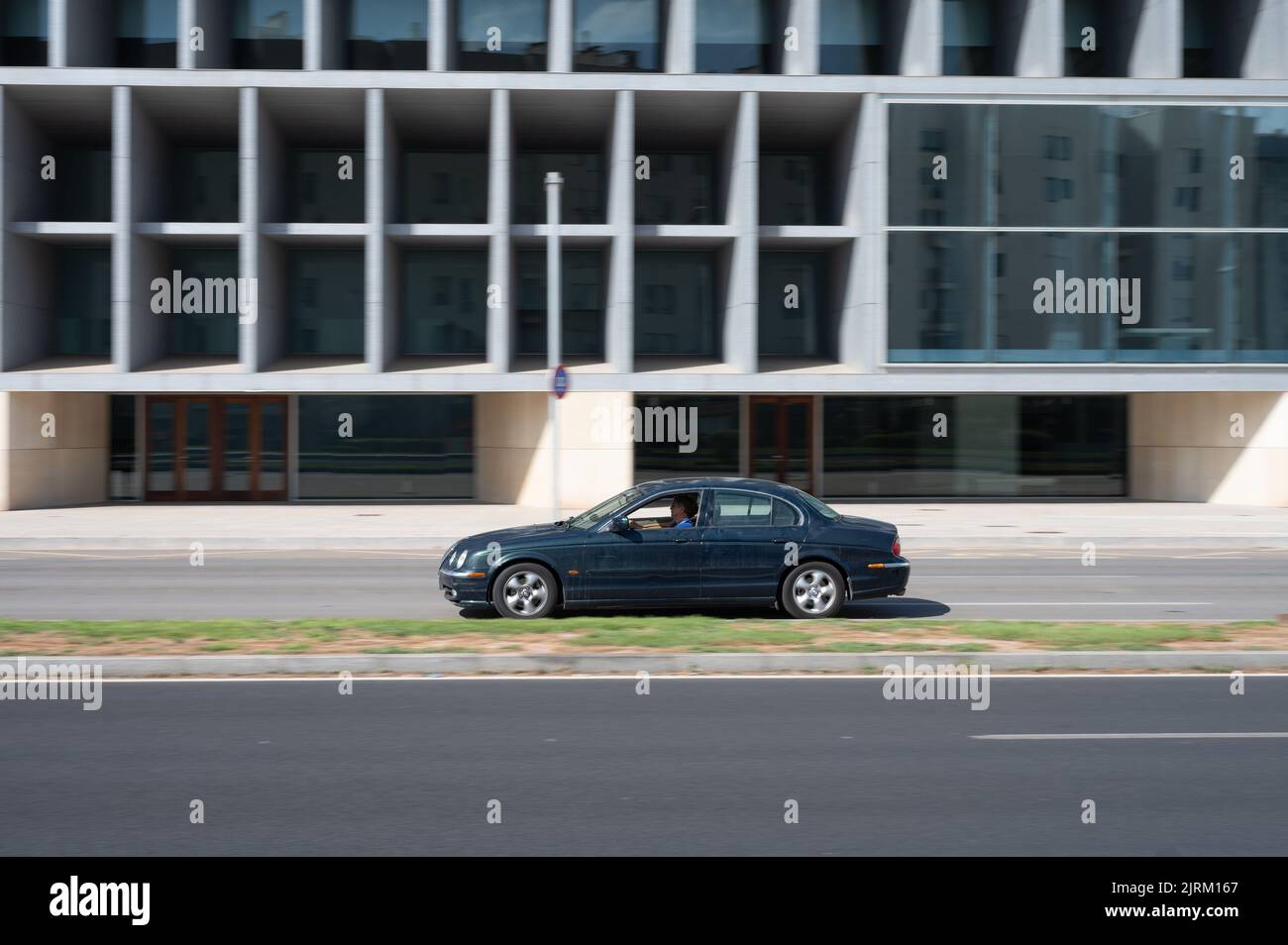 A side view of a green executive and luxury Jaguar S-Type driving in ...
