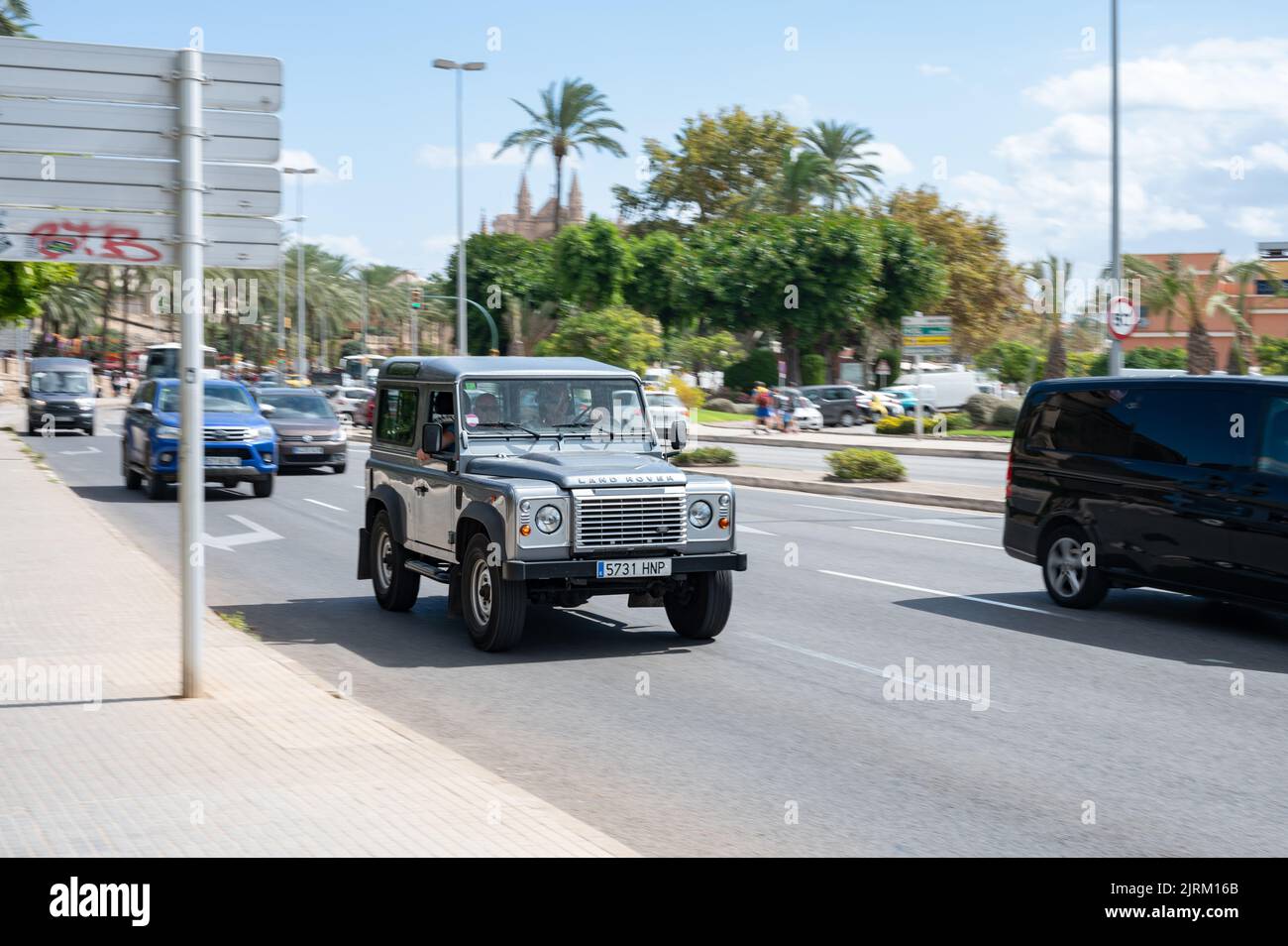 A grey Land Rover Defender SUV driving in the city of Palma with other ...