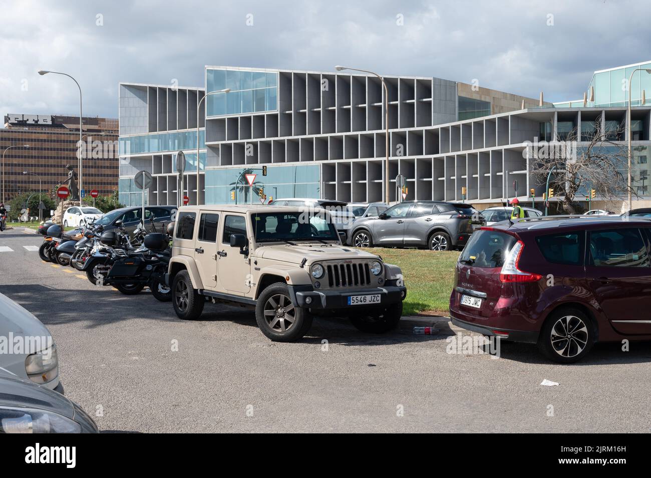 A sand-colored Jeep Wrangler Limited off-road car parked near a modern ...