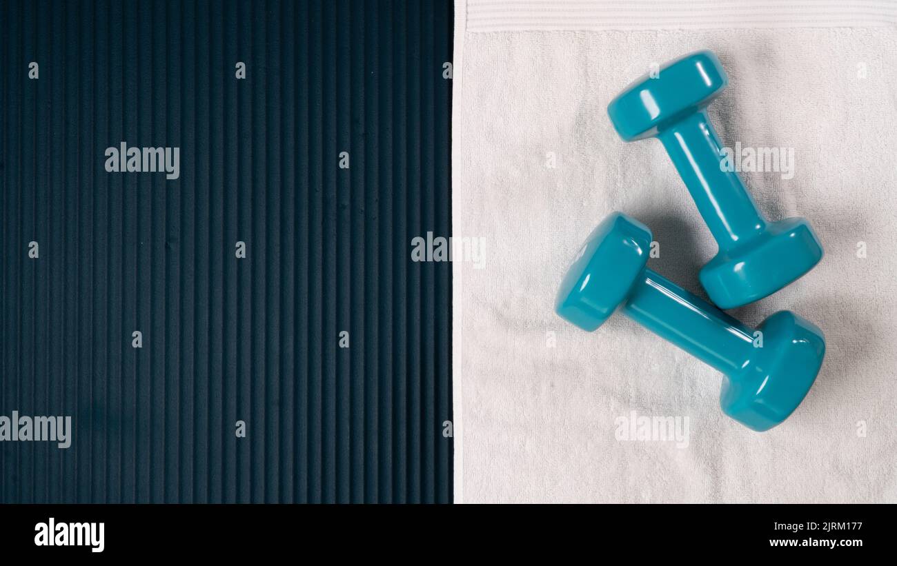Dumbbells and towel on the workout mat - sports background with space ...