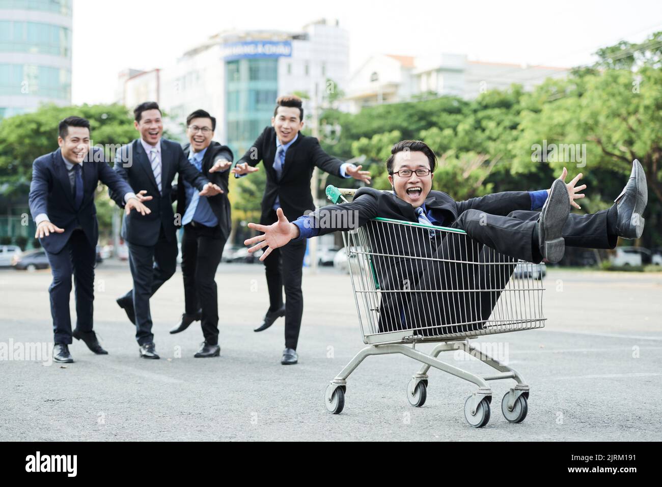 Having fun after hard working day: cheerful Asian white collar workers ...