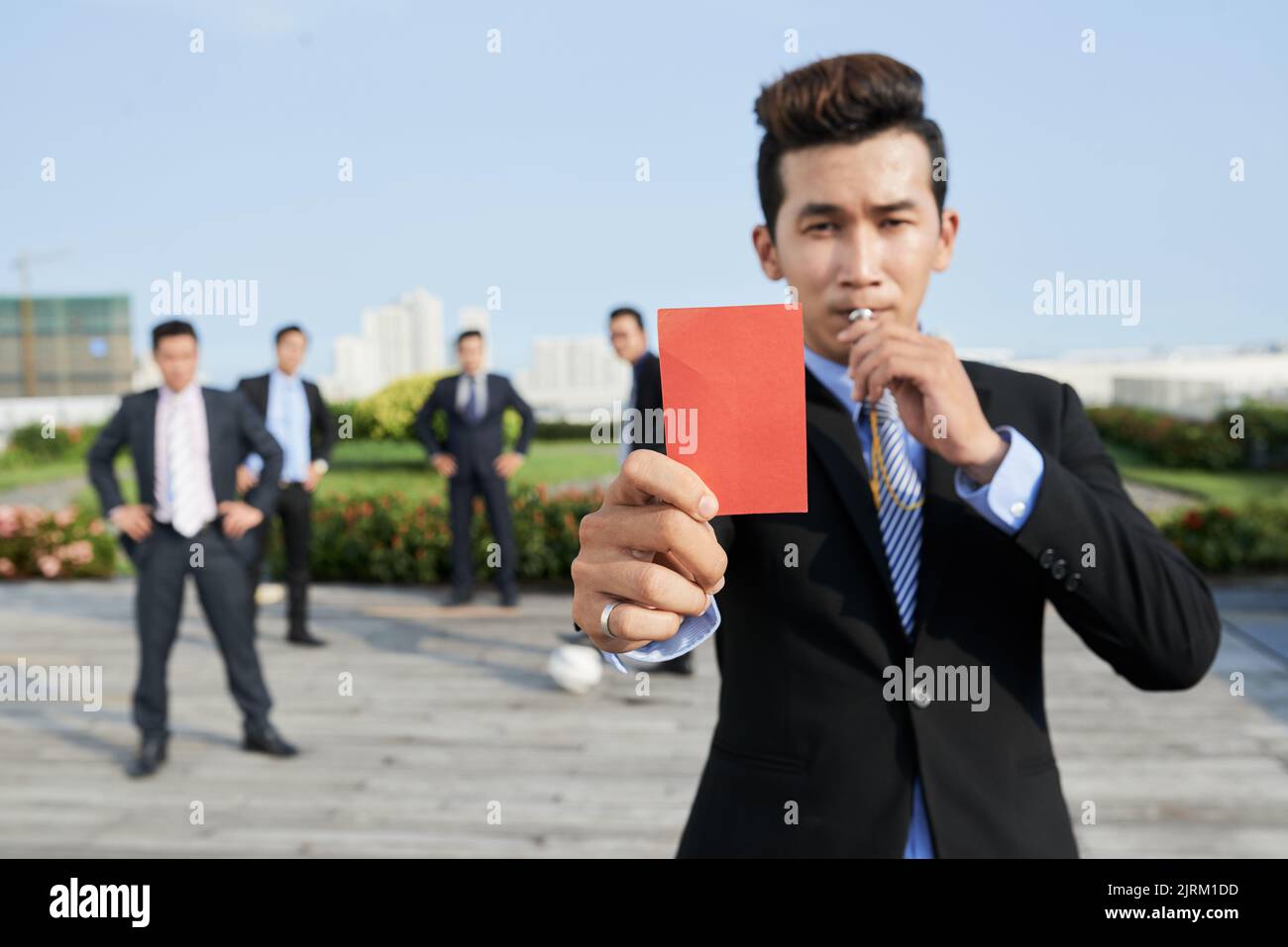 Handsome young businessman wearing classical suit blowing whistle and ...
