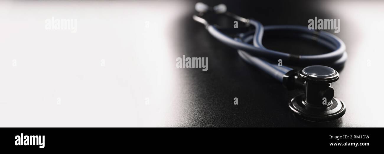 Dark blue stethoscope lying on black background closeup Stock Photo - Alamy