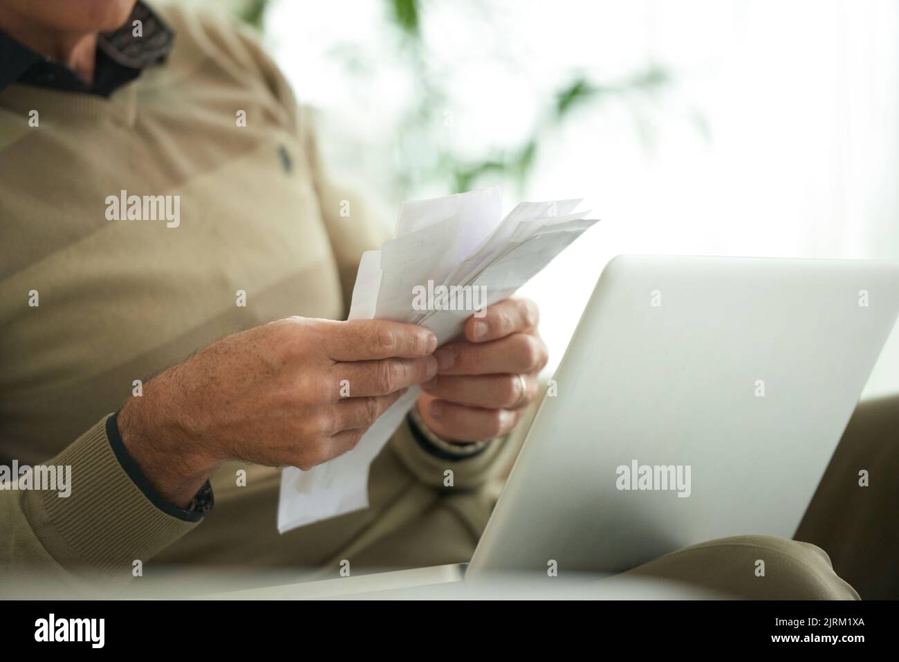 Bills and receipts in hands of senior man Stock Photo - Alamy
