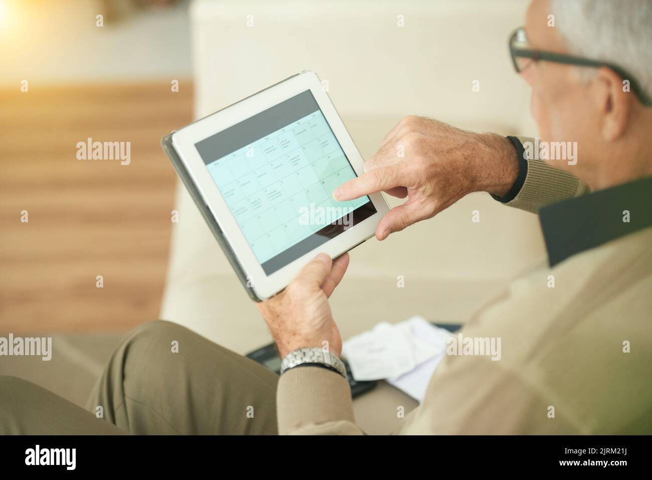 Aged man checking calendar with his plans on tablet computer Stock ...