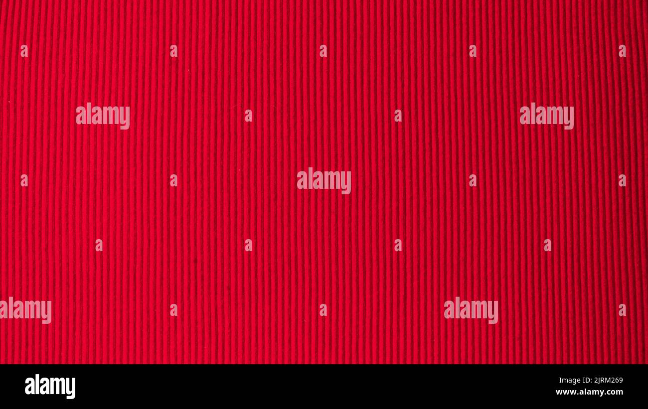 Bright red saturated background in volumetric strip fabric textile ...