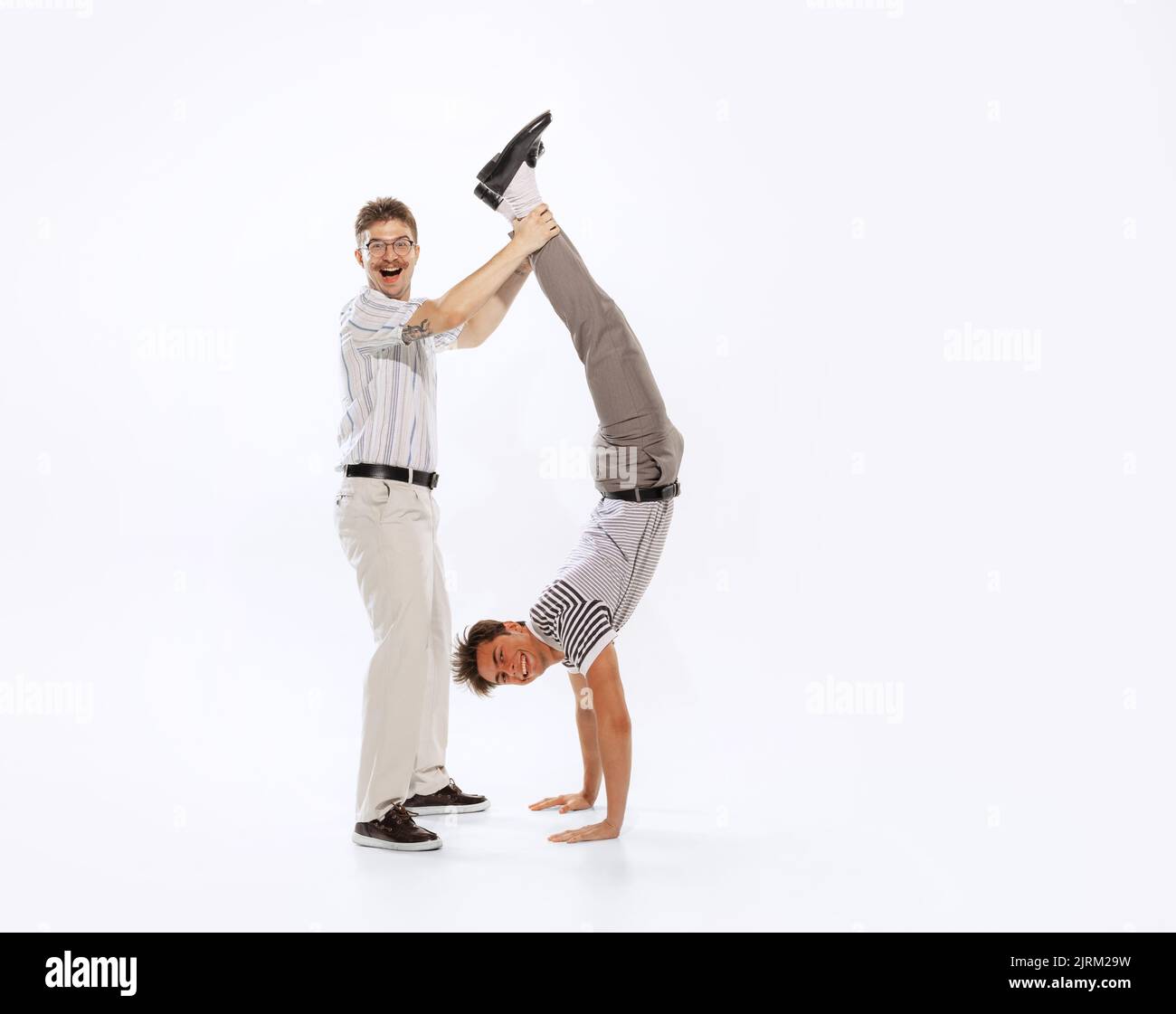 Two cheerfull dudes, young men having fun isolated on white background ...