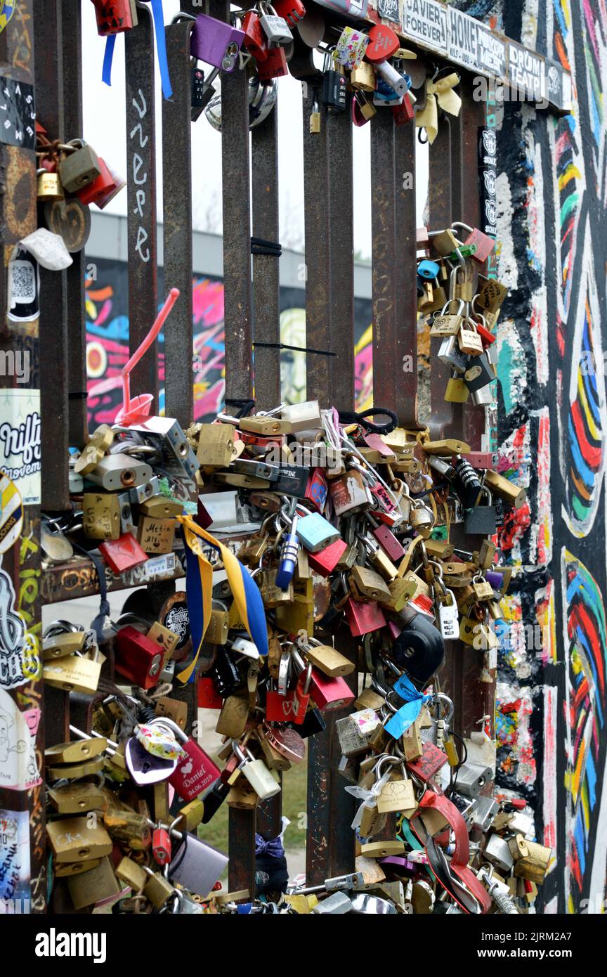 Selection of pad locks hanging on a gate with partial view of graffiti ...