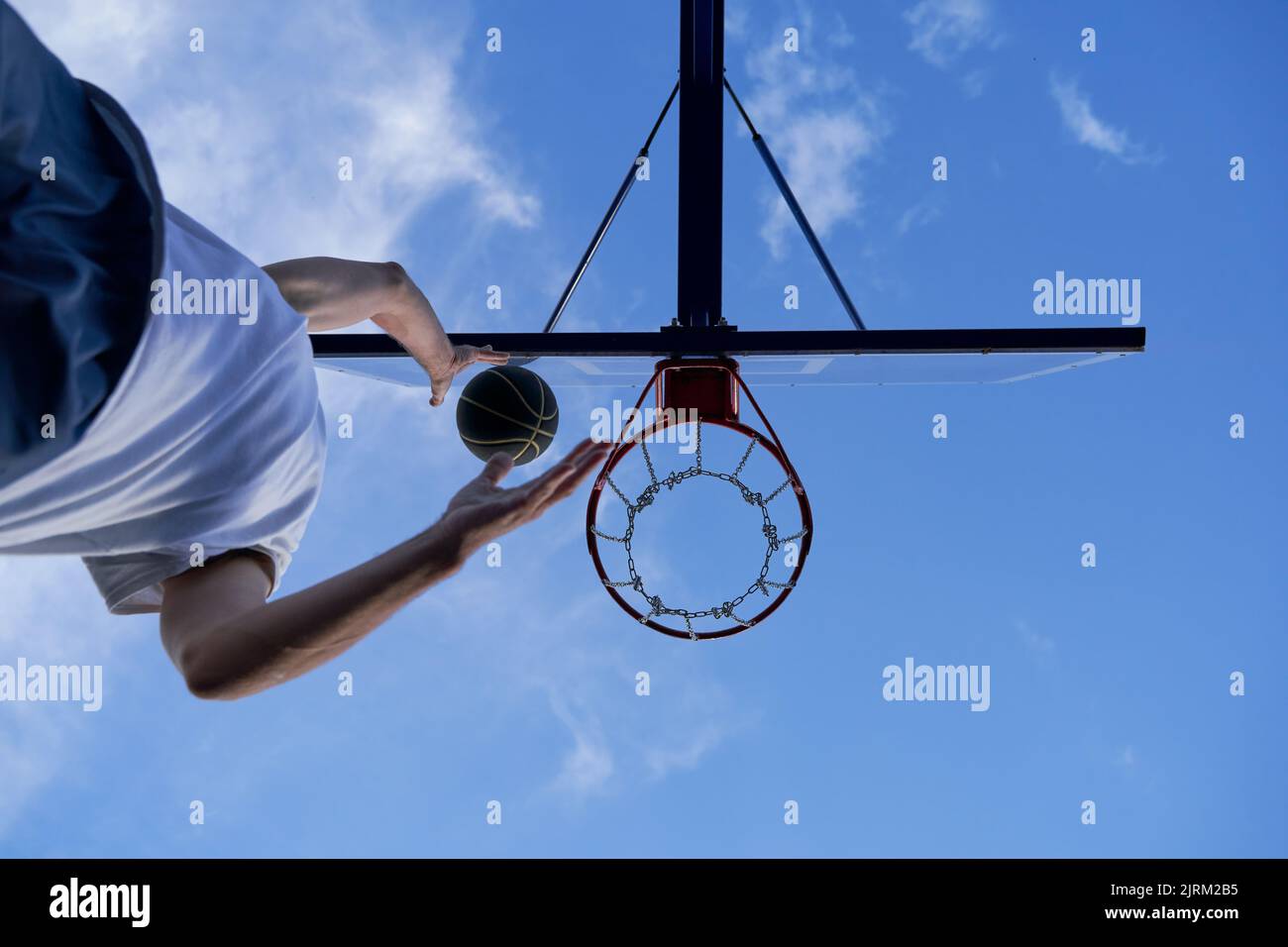 Man is training basketball on the street court. He throw ball to the ...