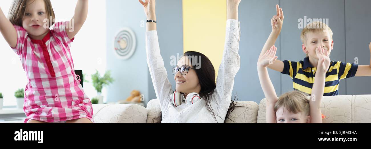 Woman with laptop and children rejoicing and raising their hands up at ...